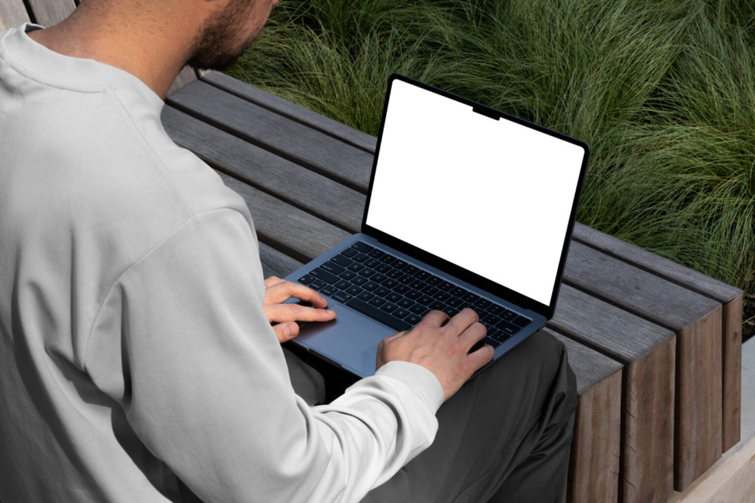 Working on MacBook outdoors Mockup - Mockup World